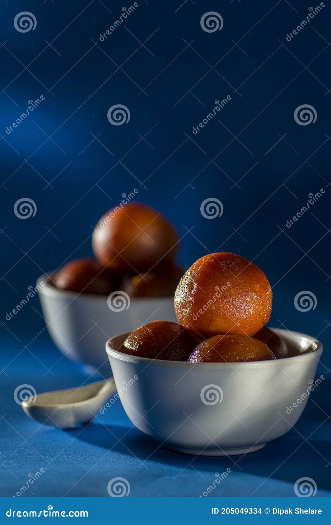 Indian Dessert : Gulab Jamun in Bowl with Spoon on Blue Background ...