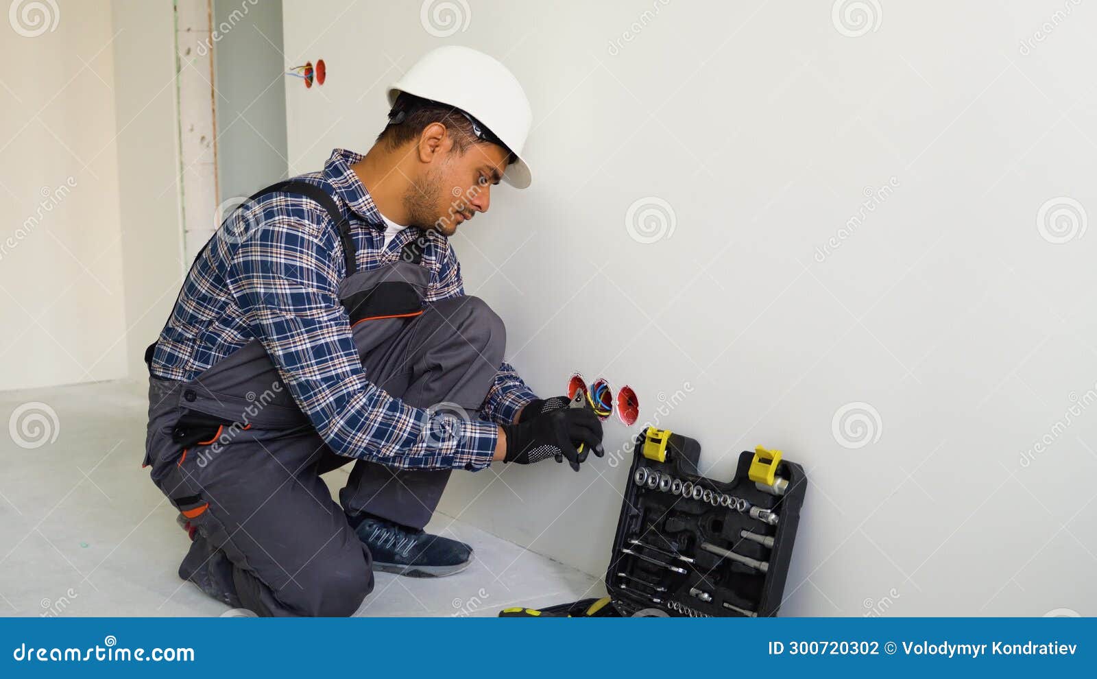 Indian Electrician in Uniform Using Pliers while Replacing a Socket in ...