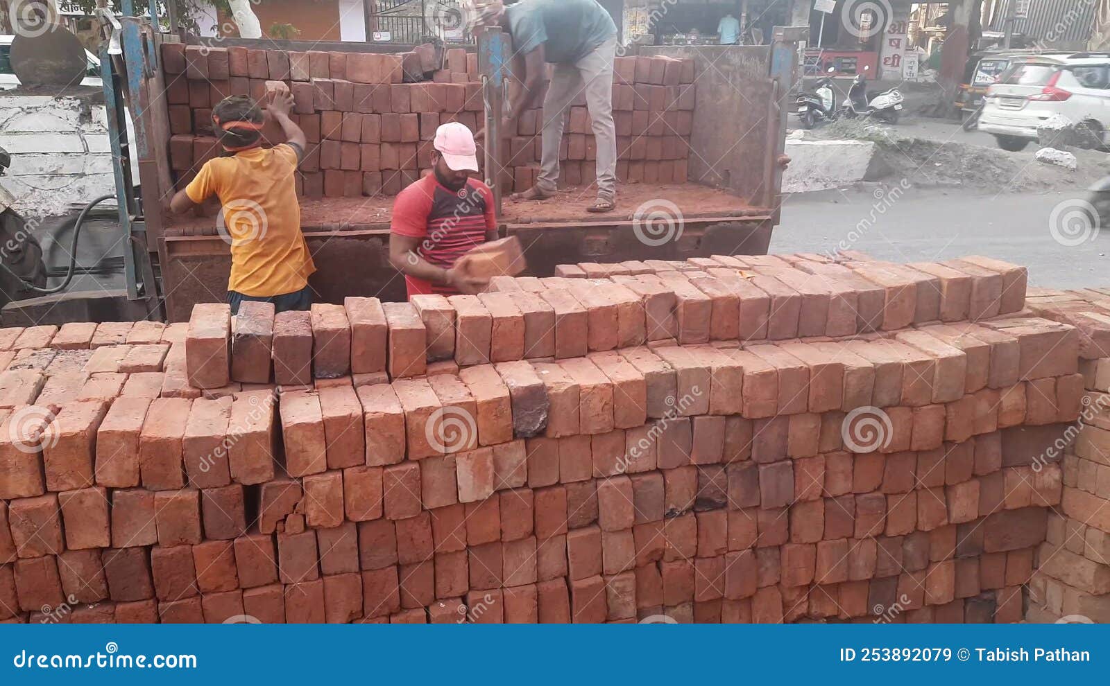 The Indian Labor is Unloading Red Bricks from the Tractor Trolley at ...