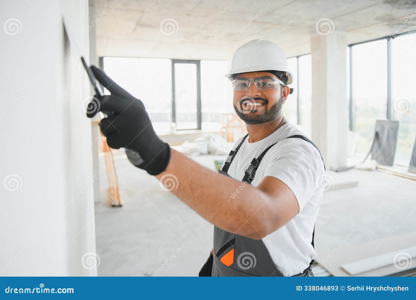 Indian Male Builder in Work Overalls Plastering a Wall Using a ...