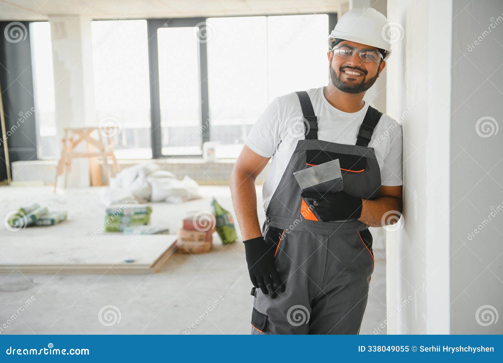 Indian Male Builder in Work Overalls Plastering a Wall Using a ...