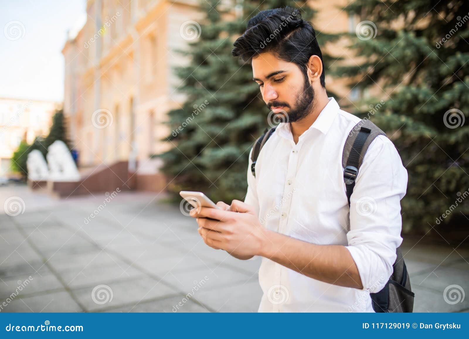 Handsome Young Indian Male Student Texting on Smartphone in the Street ... Handsome Young Indian Male Student Texting on Smartphone in the Street ...