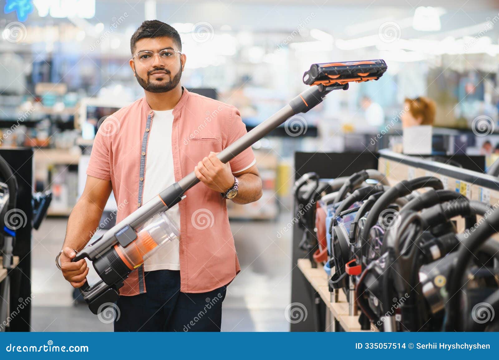 An Indian Man is Choosing a New Vacuum Cleaner in an Electronics Store ...