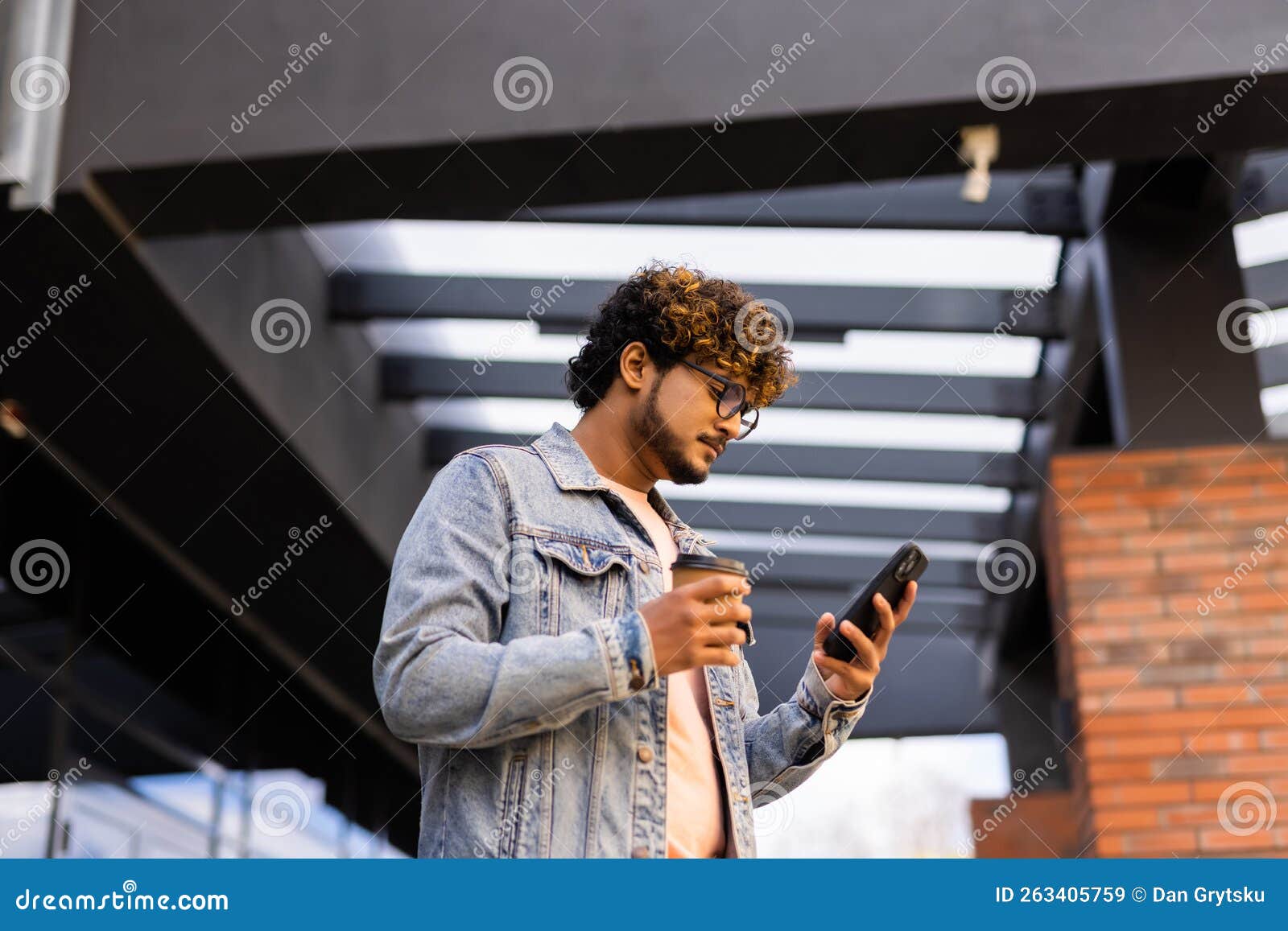 Indian Young Man Use Phone Drinking Phone while Walking on the Street ...