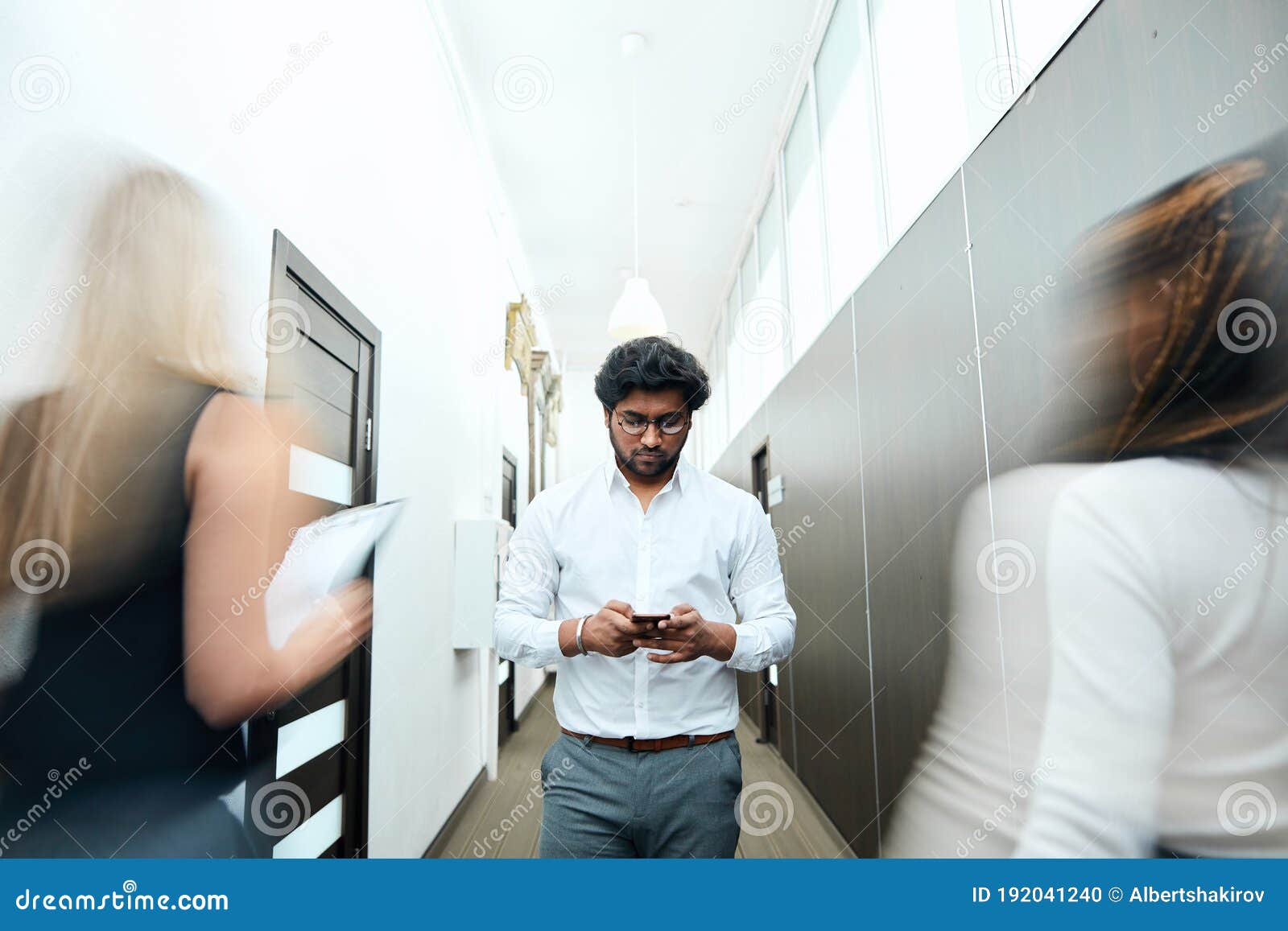 Indian Office Worker is Using Smartphone while Walking in the Office ...
