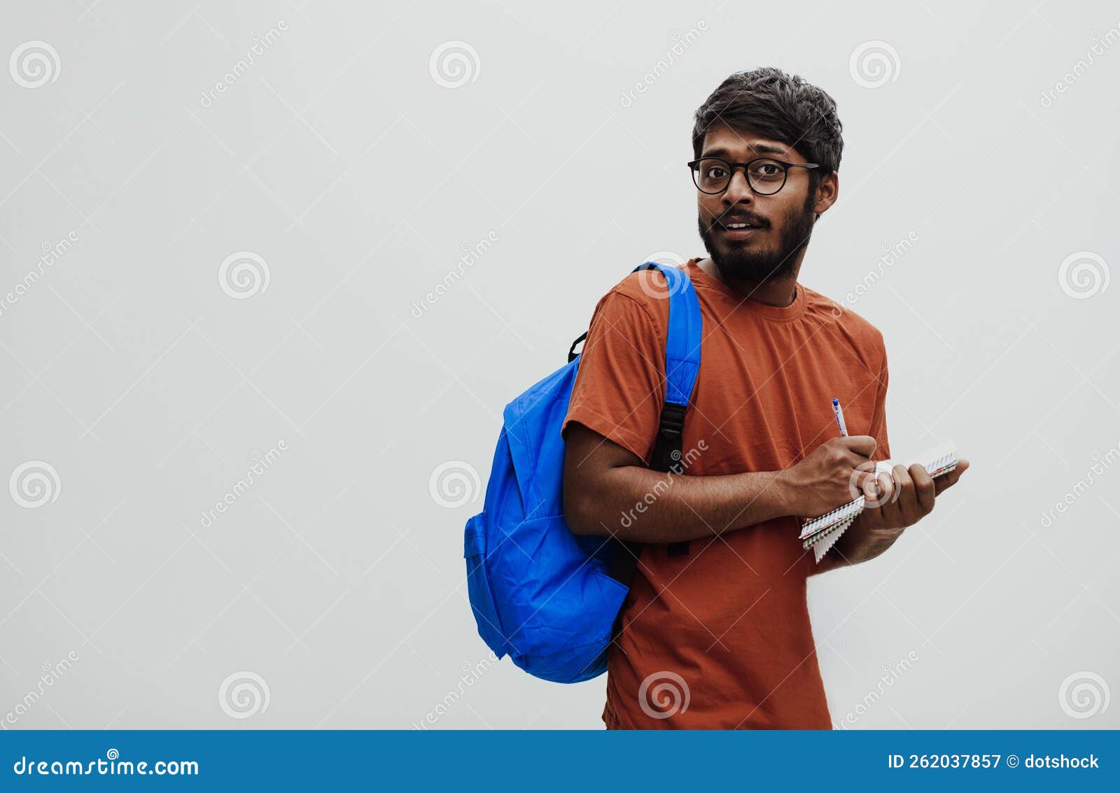 Indian Student with Blue Backpack, Glasses and Notebook Posing on Gray ...