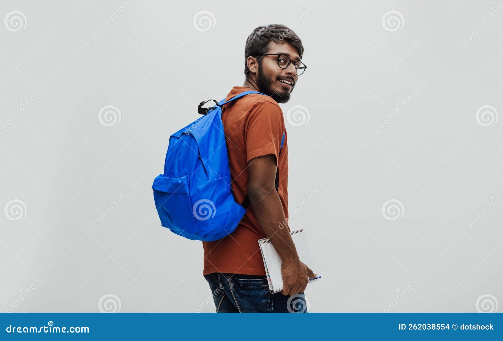 Indian Student with Blue Backpack, Glasses and Notebook Posing on Gray ...