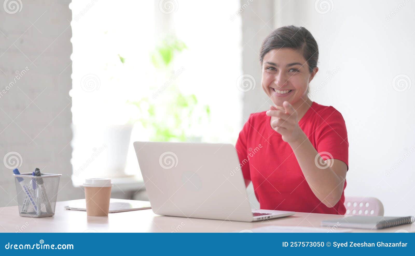 Indian Woman Pointing at Camera while Using Laptop in Office Stock ...