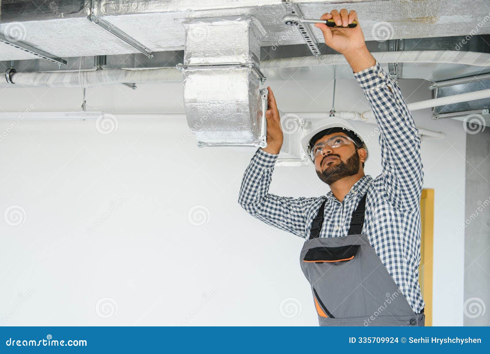 An Indian Worker Inspects the Ventilation System in an Office Building ...