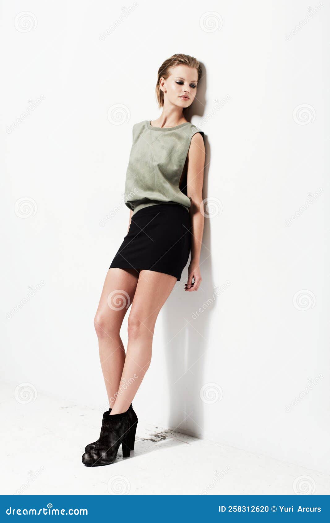 Indifference. a Stunning Model Leaning Against a White Wall and Looking ...