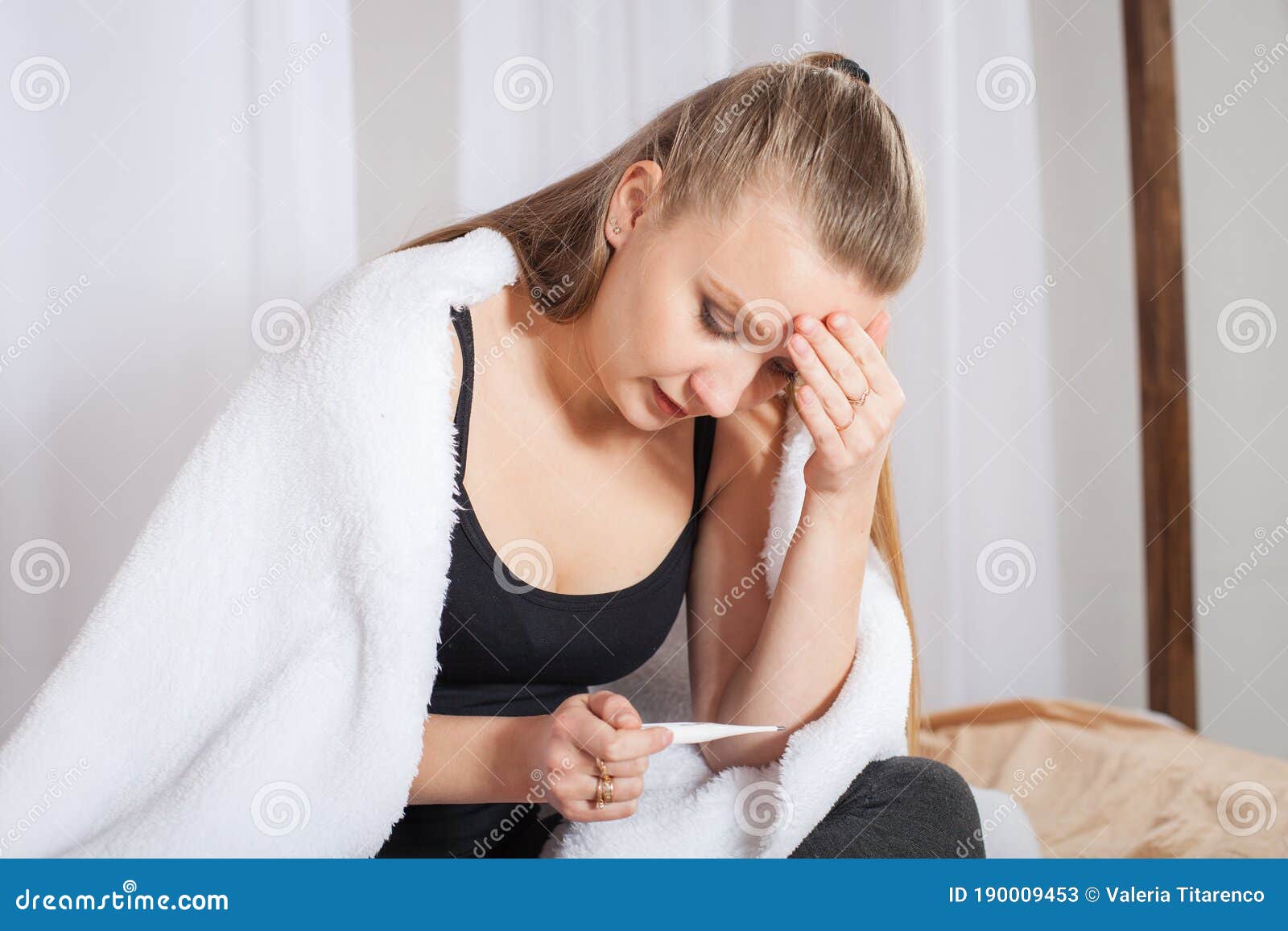 Indisposed Woman Feeling Her Temperature while Resting on the Sofa ...