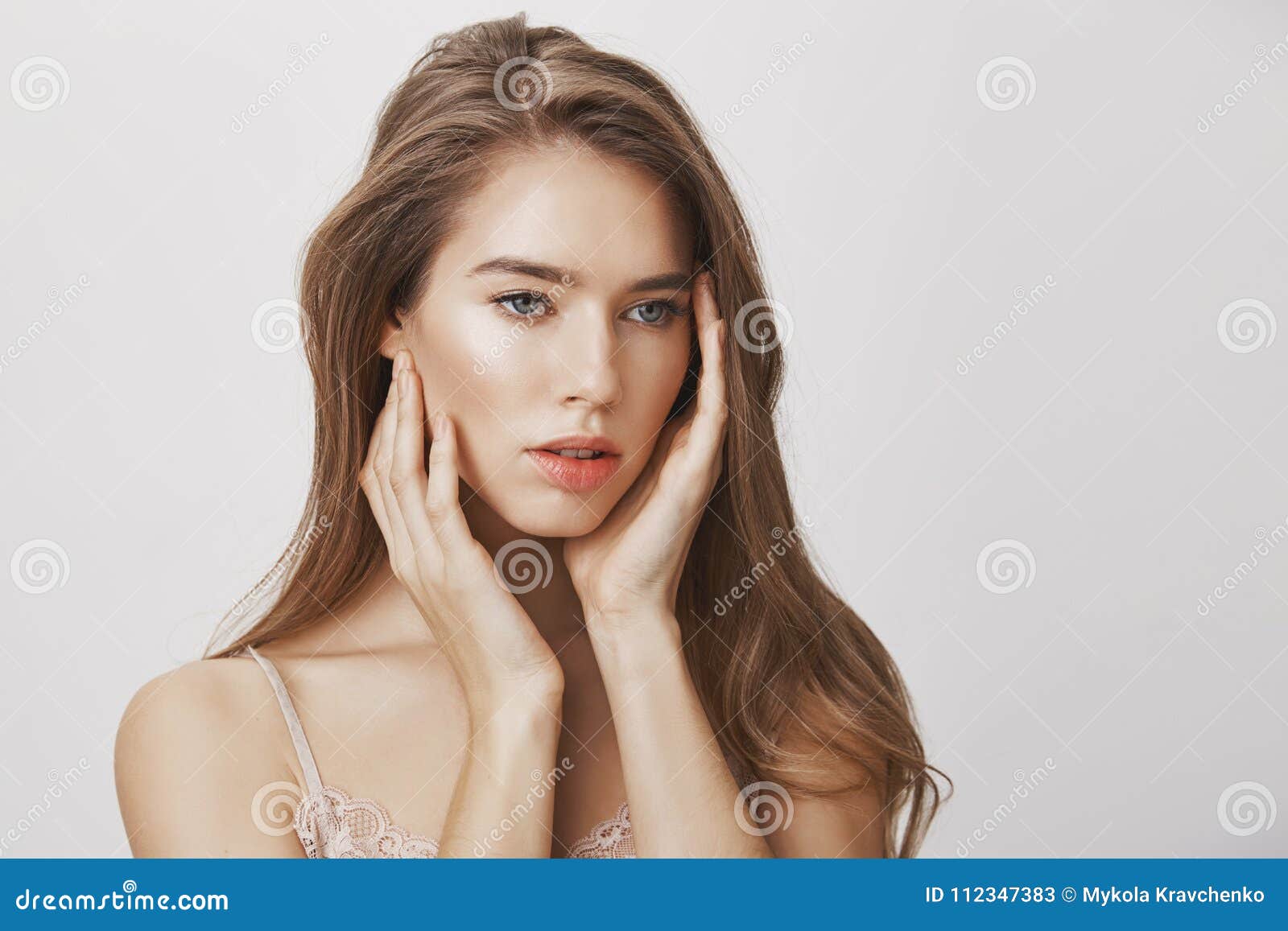 Indoor Shot Of Attractive Confident European Female Model Touching Face