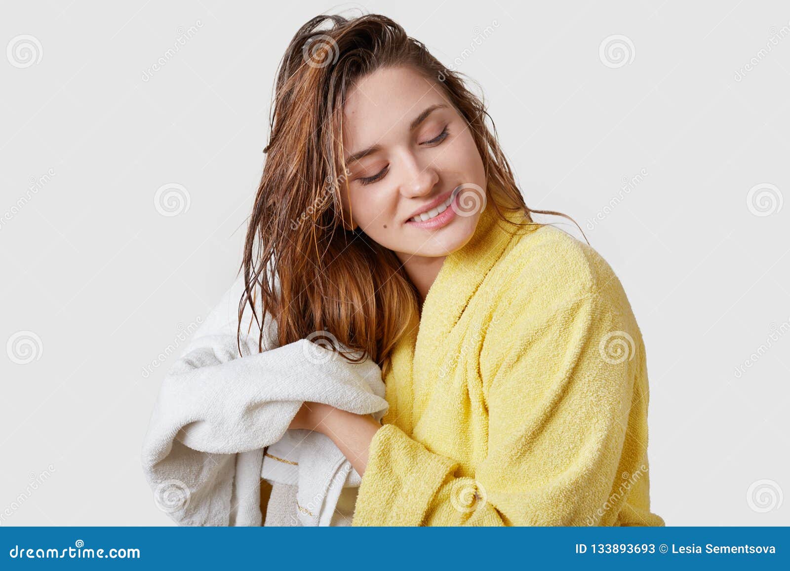Indoor Shot Of Beautiful Woman Wipes Wet Hair With Towel Dressed In