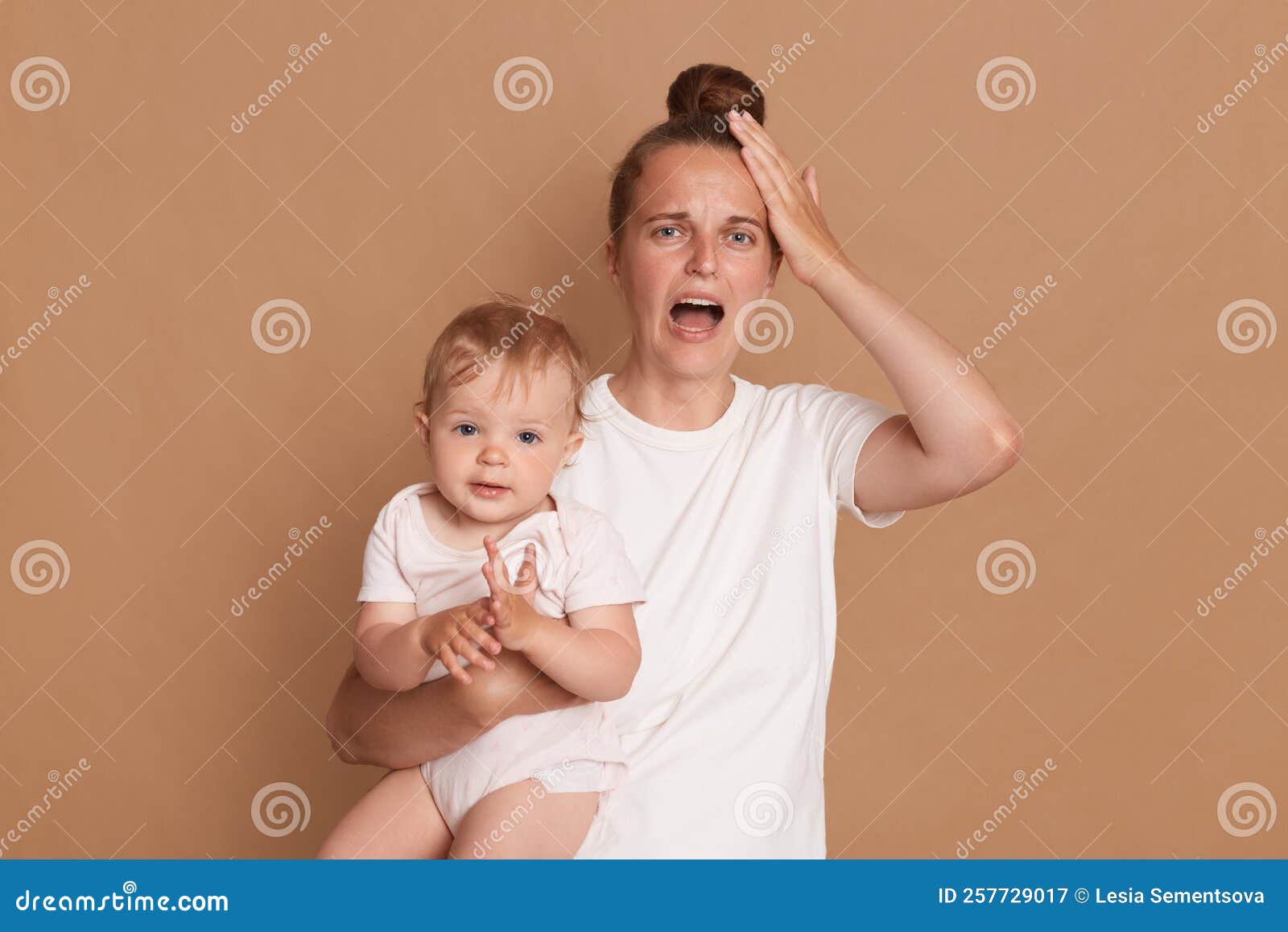 Indoor Shot Of Stressed Depressed Young Mother With Bun Hairstyle