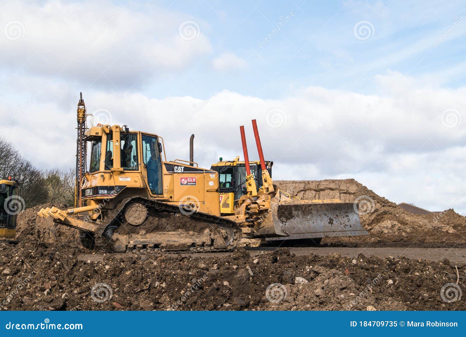 A Bulldozer Moving Sand On A Sandy Beach With The Ocean Water In The ...