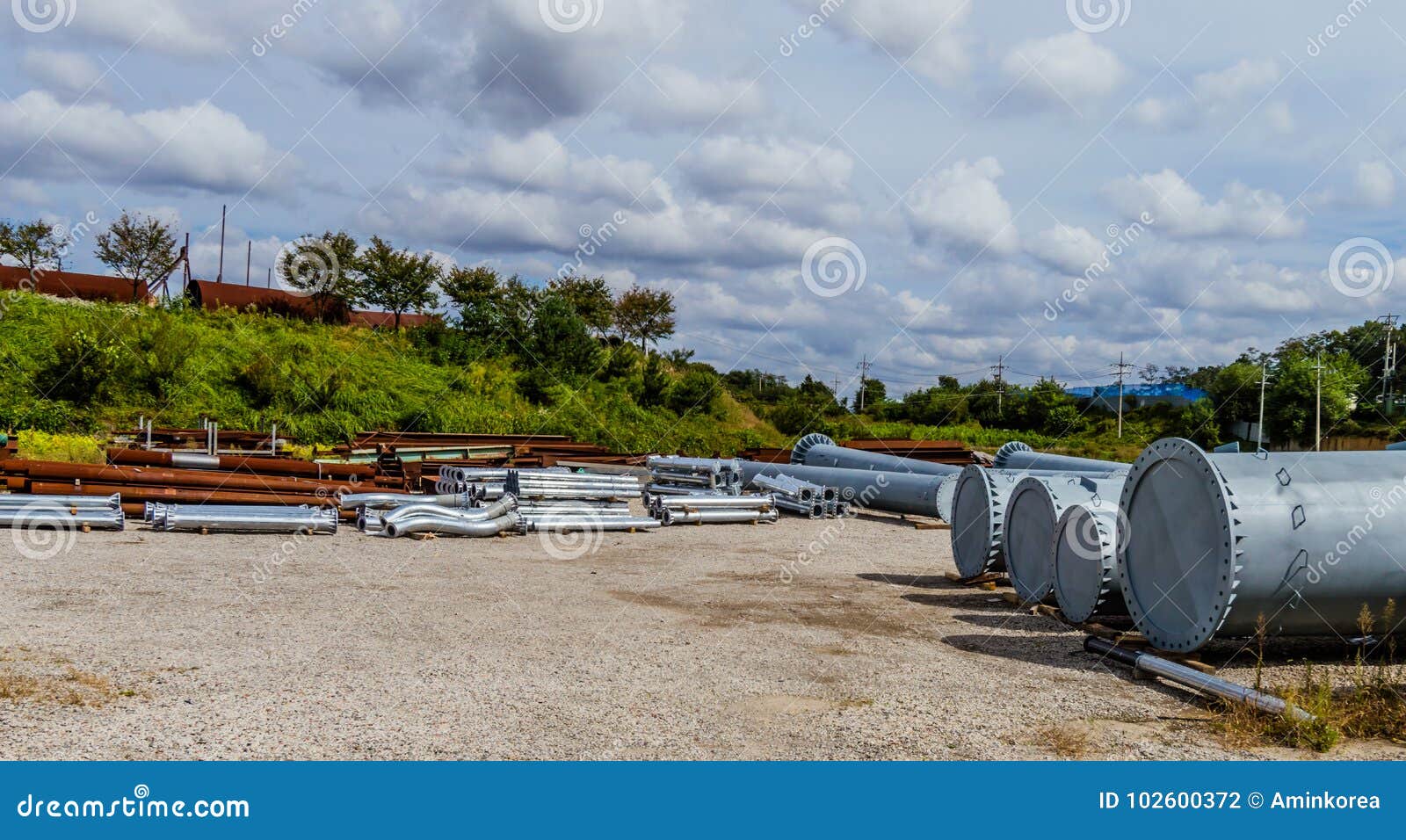 Industrial Pipe Storage Lot Under a Sky Filled with White Puffy Stock ...