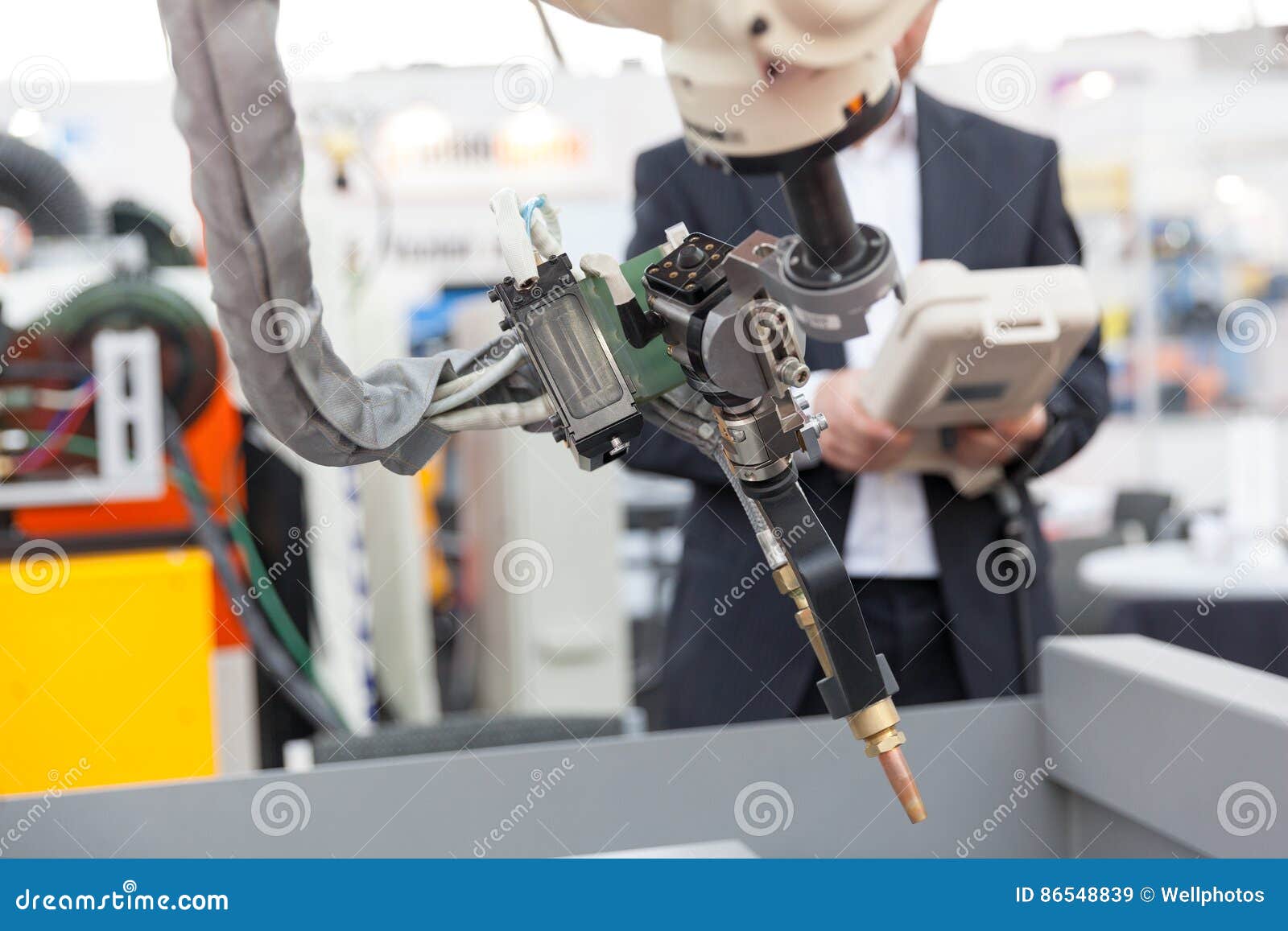 Industrial Welding Robotic Arm, Blurred Operator in the Background ...