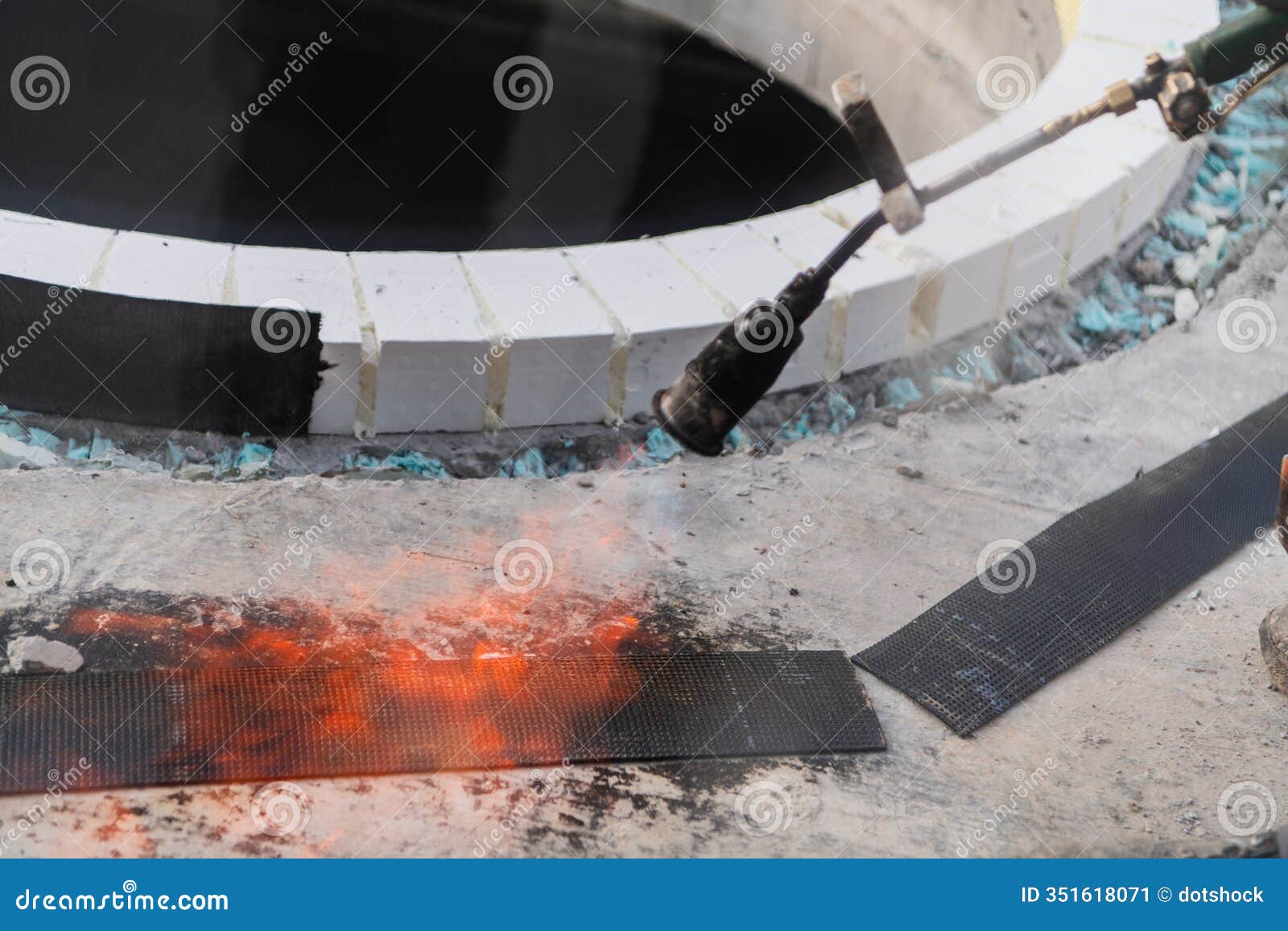 An Industrial Worker Uses Fire To Soften a Rubber Underlay for Floor ...