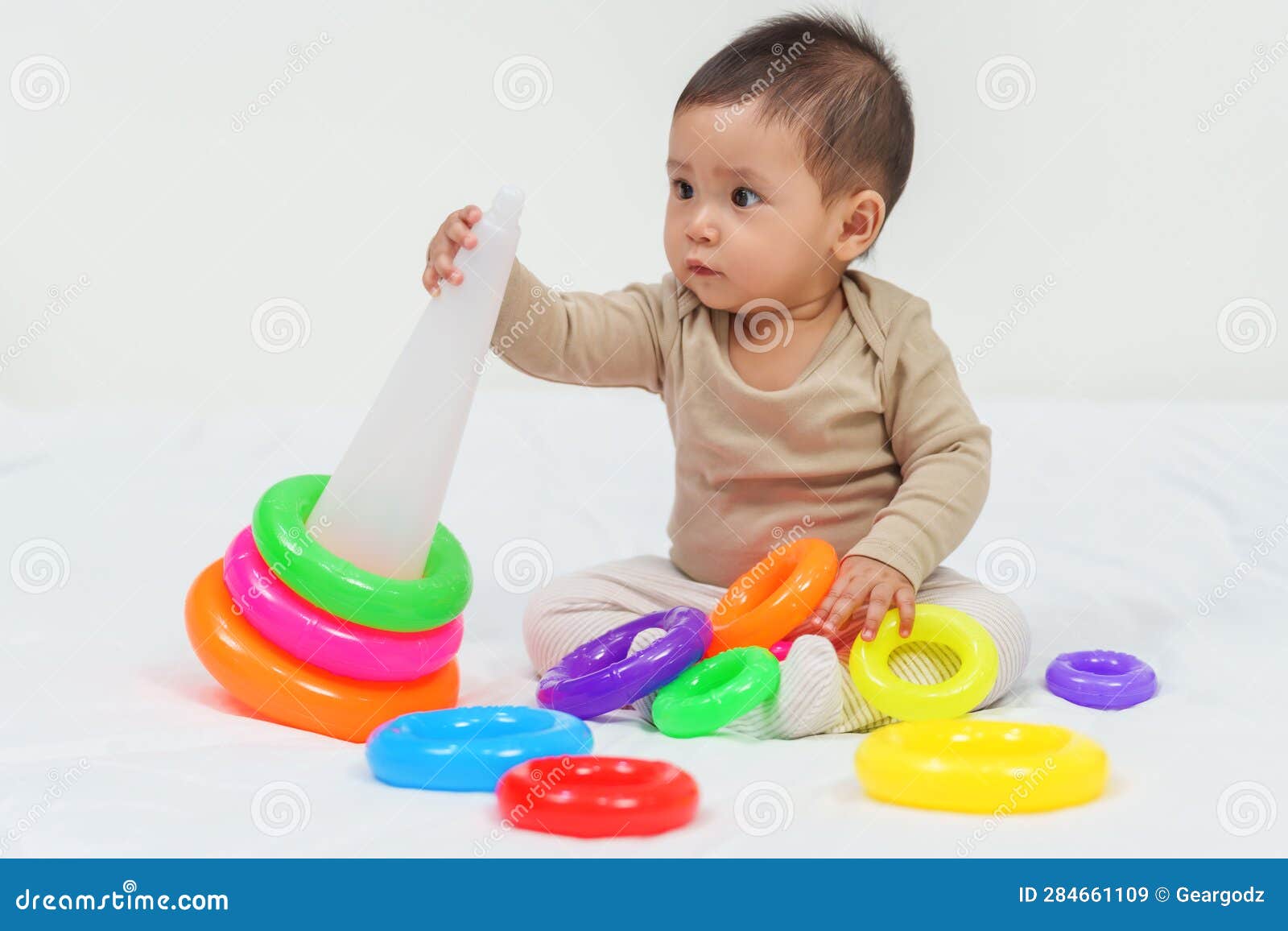 Infant Baby Playing the Pyramid Toy with Colored Rings on Bed Stock ...