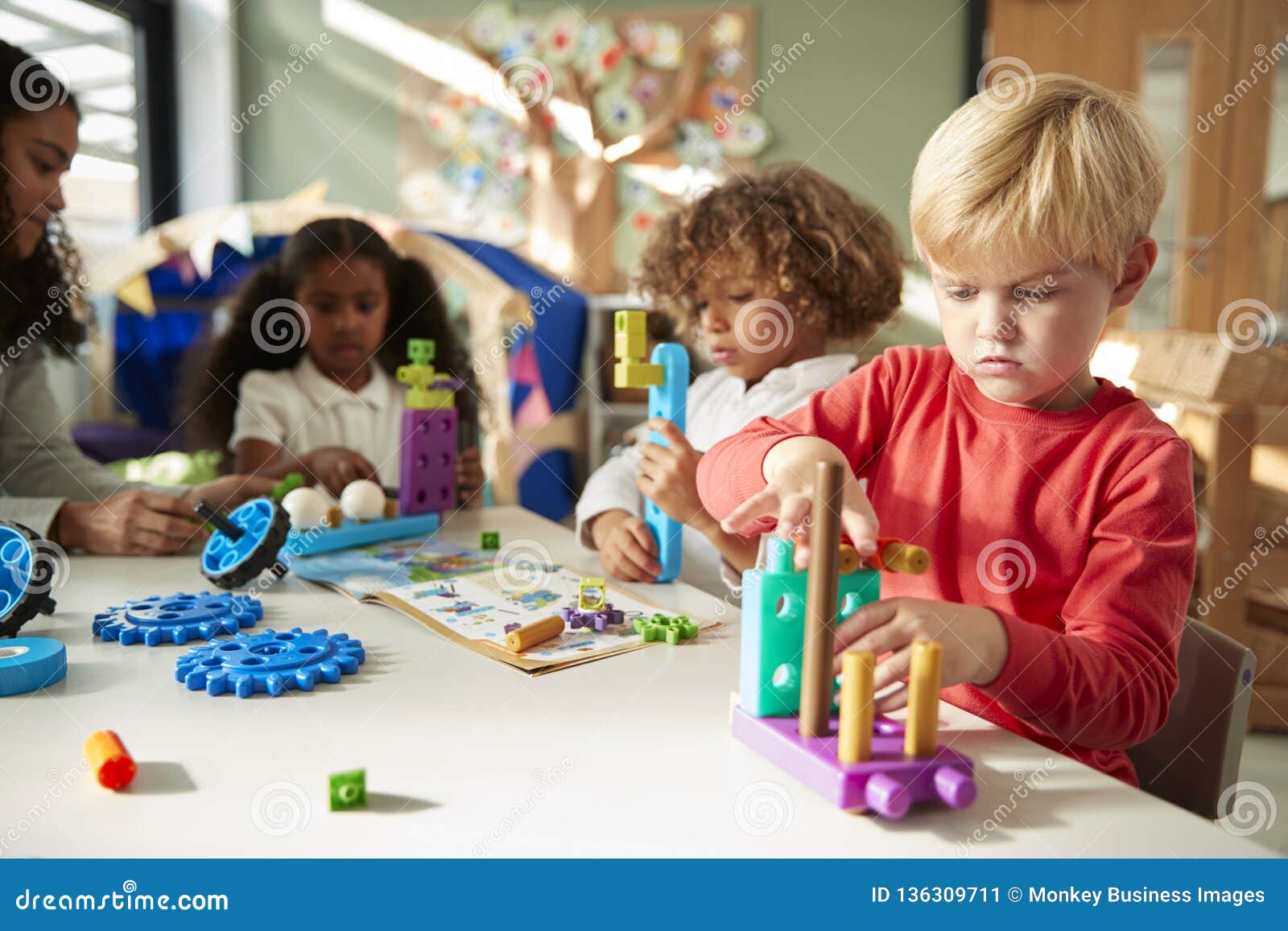 Infant School Boy Sitting at a Table Using Educational Construction ...