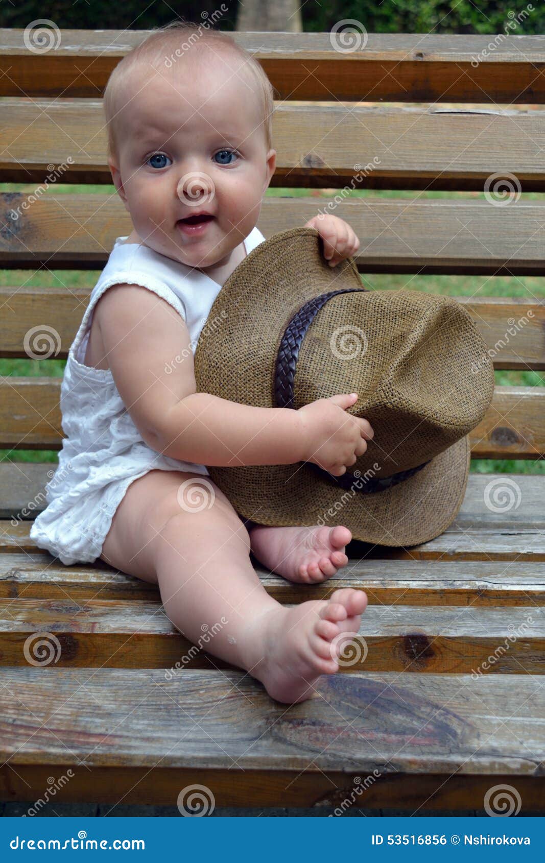 An Infant Sitting on the Bench with the Hat Stock Photo - Image of baby ...