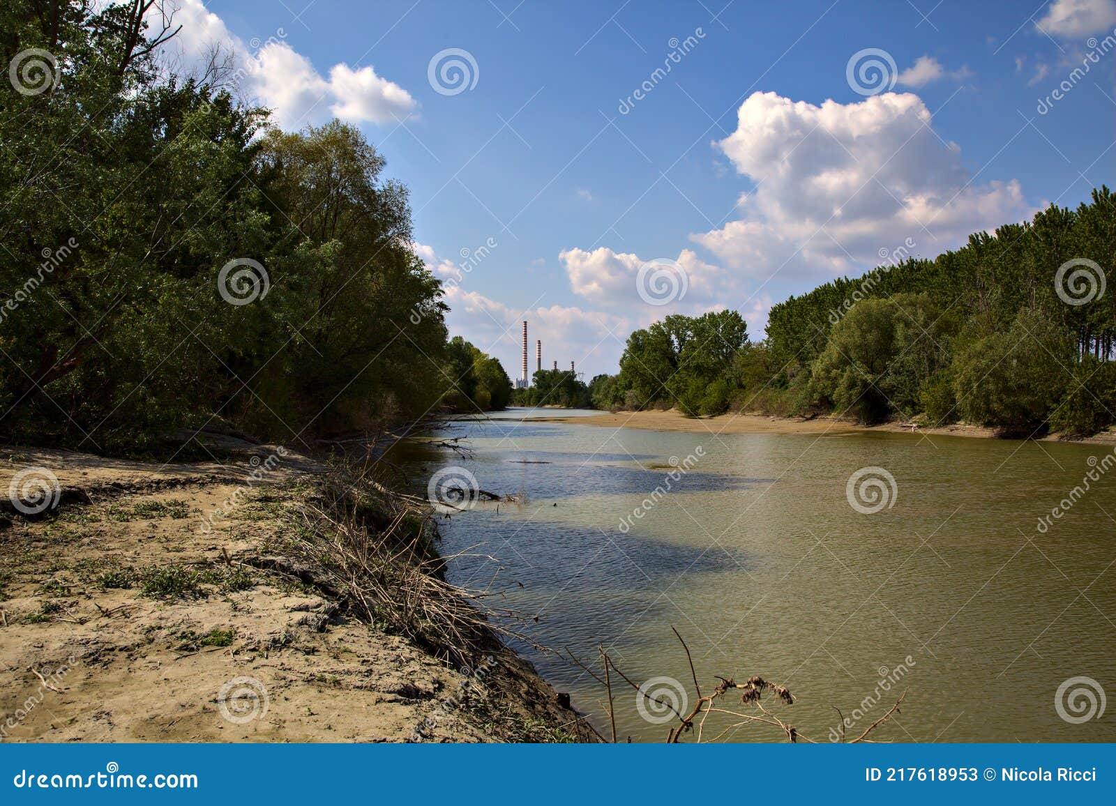 Inlet of a River with a Power Plant in the Distance Framed by Trees on ...