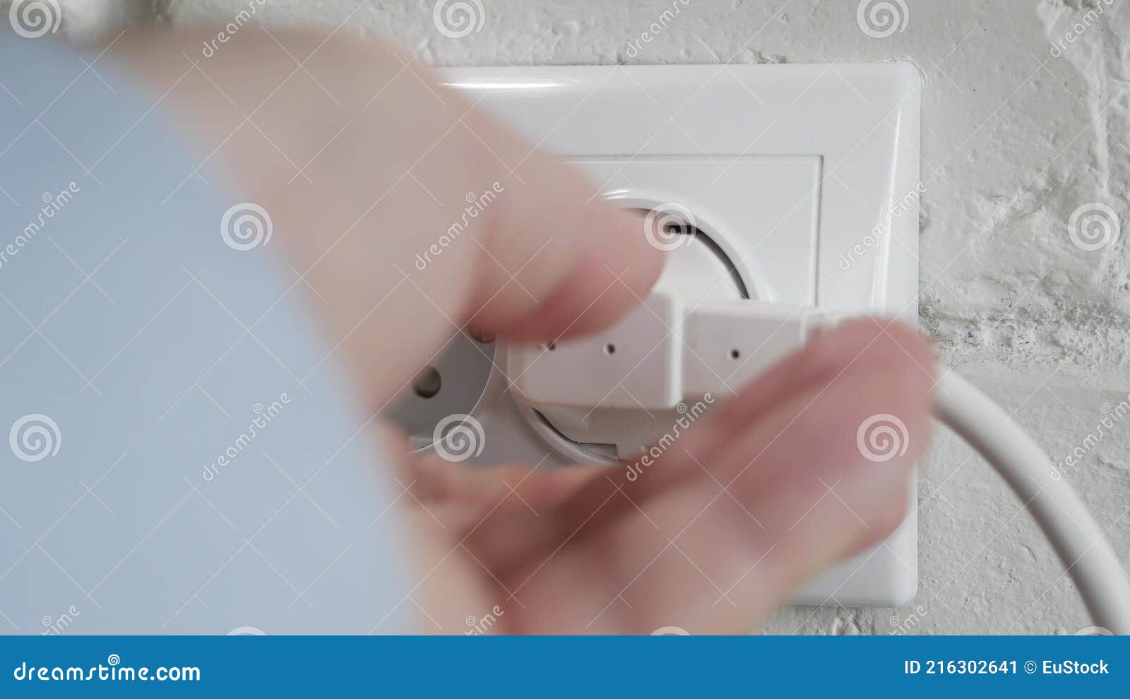 Inserting an Electrical Power Cord into a Socket on the Office Wall ...