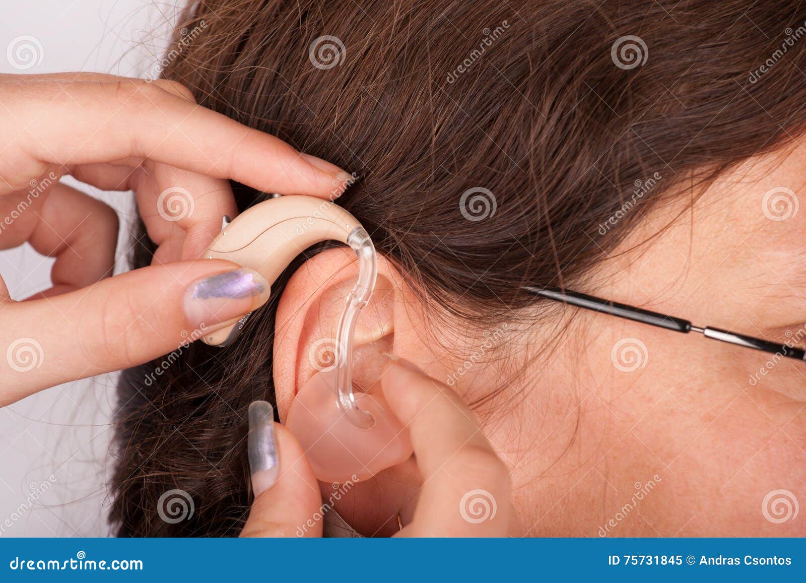 Inserting a hearing aid stock image. Image of clinic - 75731845