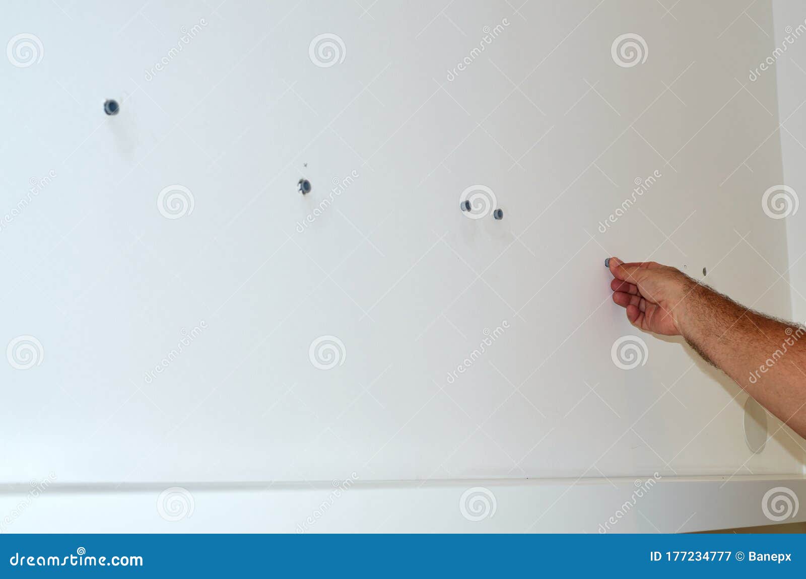 Inserting wall plugs stock image. Image of drywall, plug - 177234777