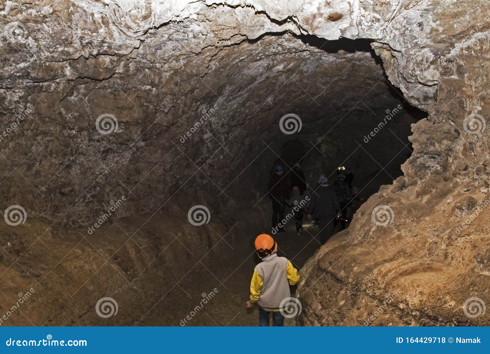 Inside a Lava Cave a Family with Flashlights and Helmets on the Island ...