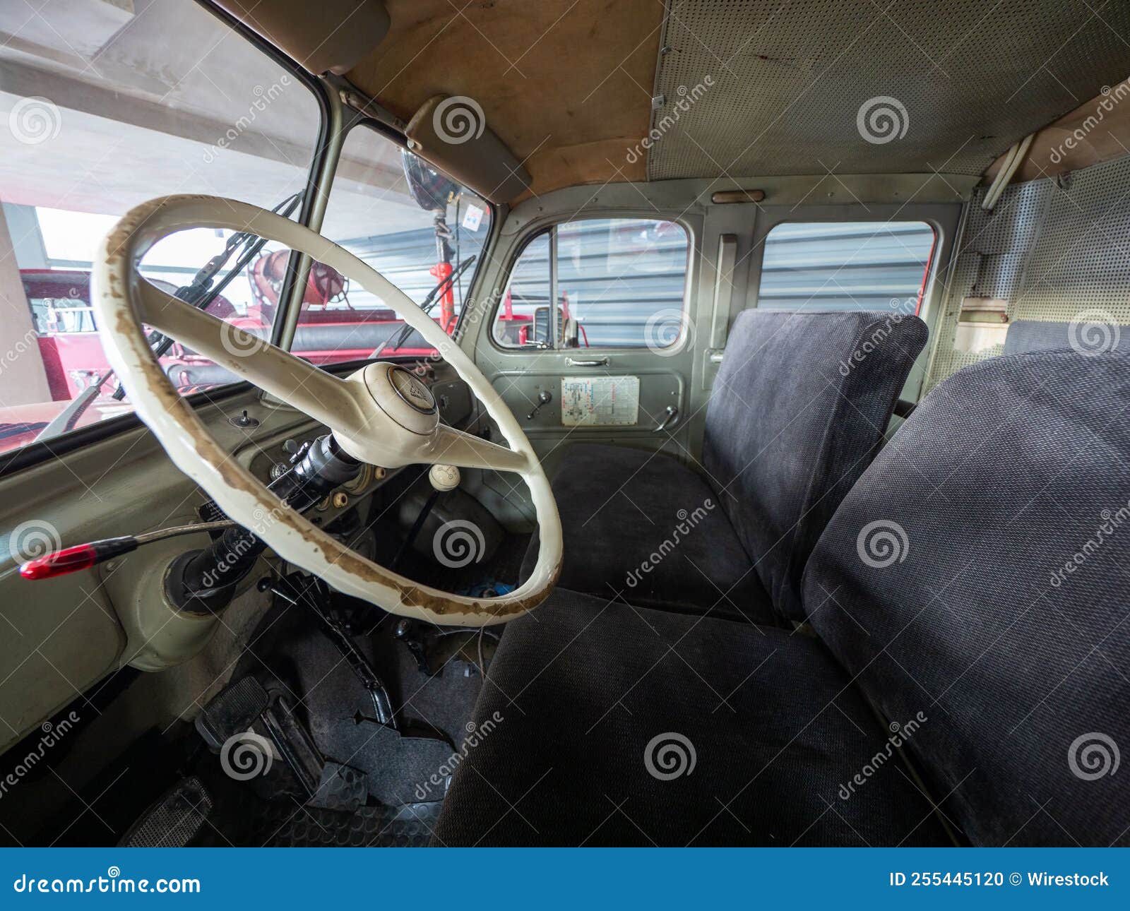 Inside View of an Old Fire Truck with Black Seats and a White Steering ...