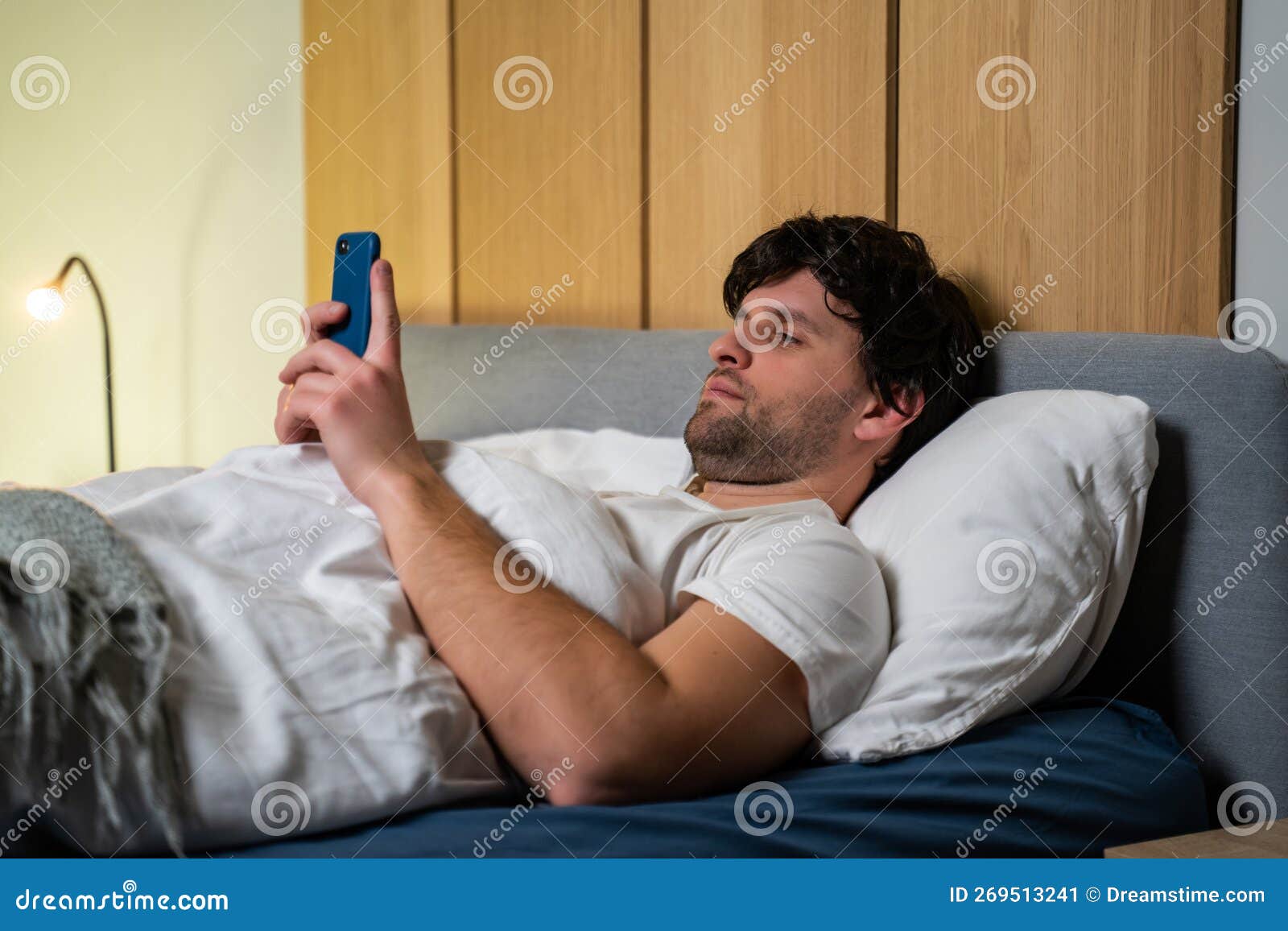 Insomnia and Mobile Phones. a Man is Lying on a Bed and Using a ...