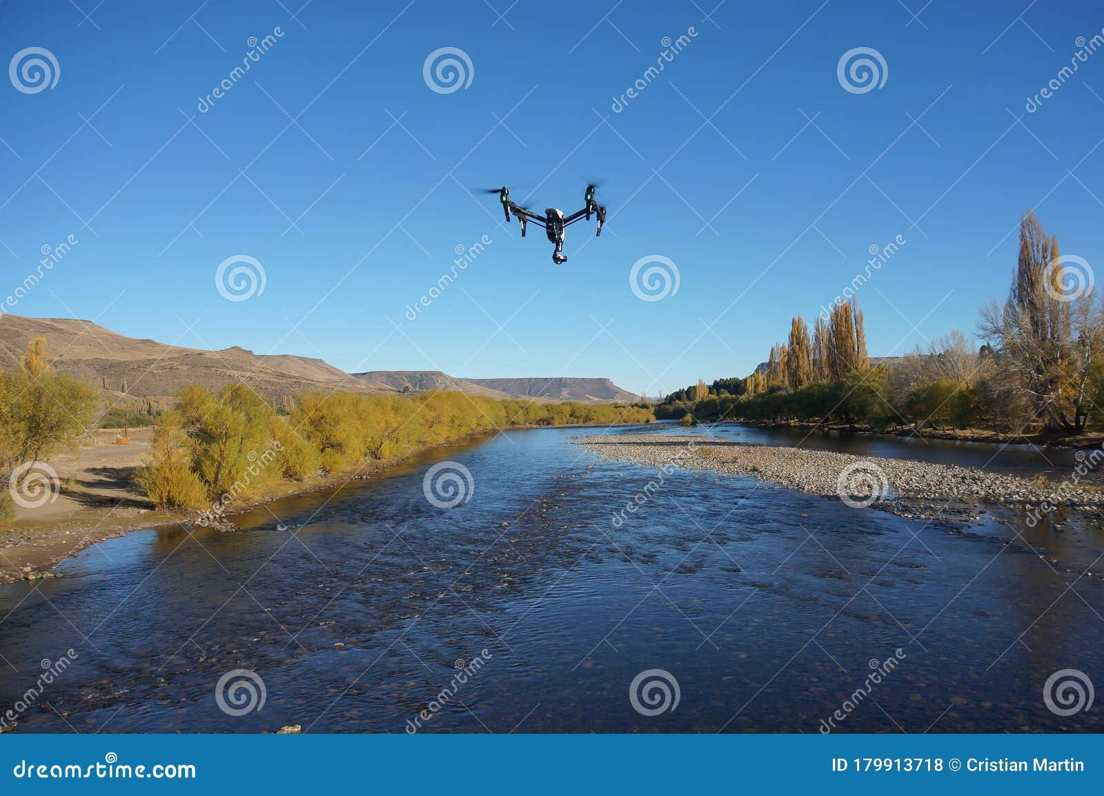 Inspire Quadcopter Drone Flying Over River. Back View Stock Photo ...
