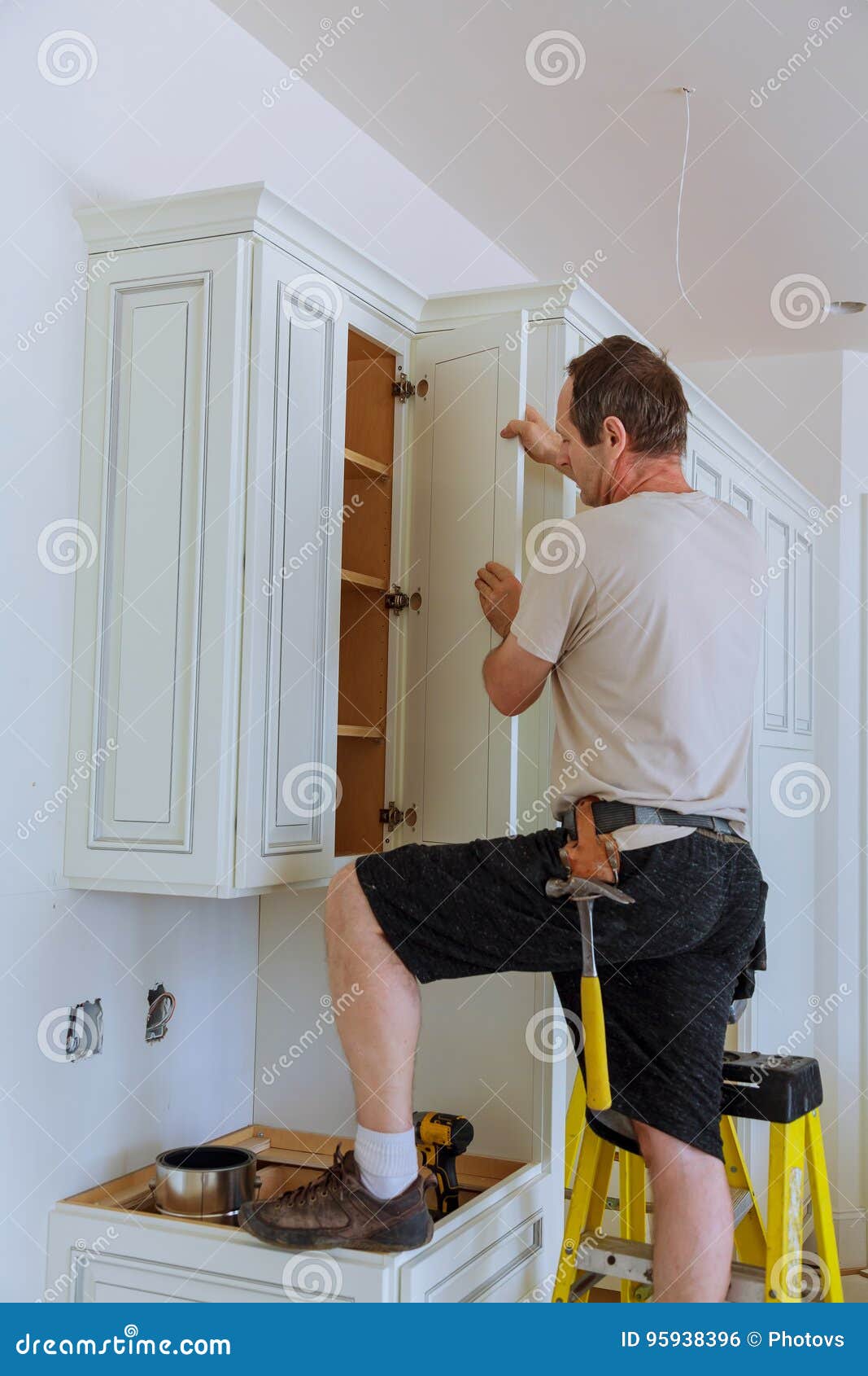 Installation of Kitchen. Worker Installs Doors To Kitchen Cabinet Stock ...