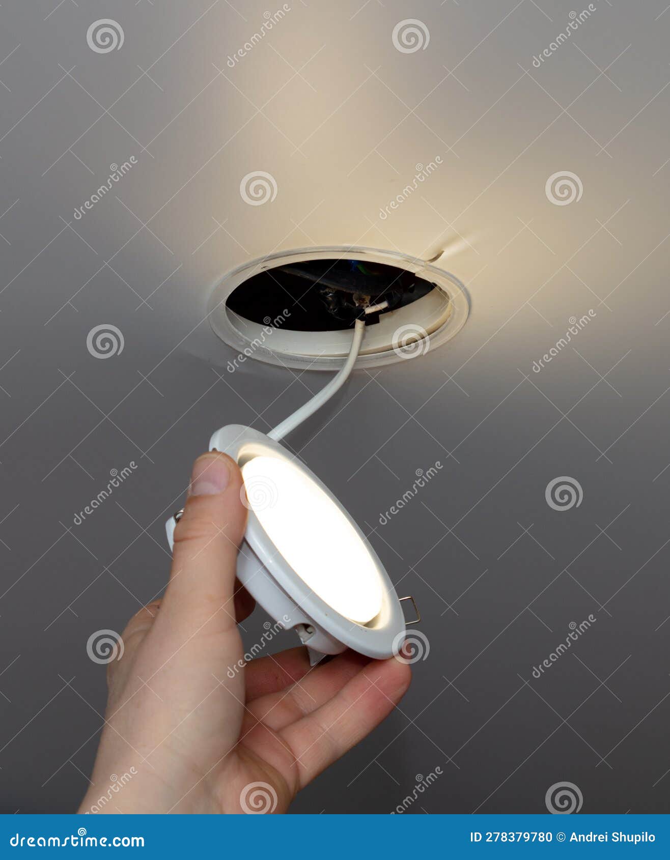 Installation of a Light Bulb in a Stretch Ceiling Stock Photo - Image ...