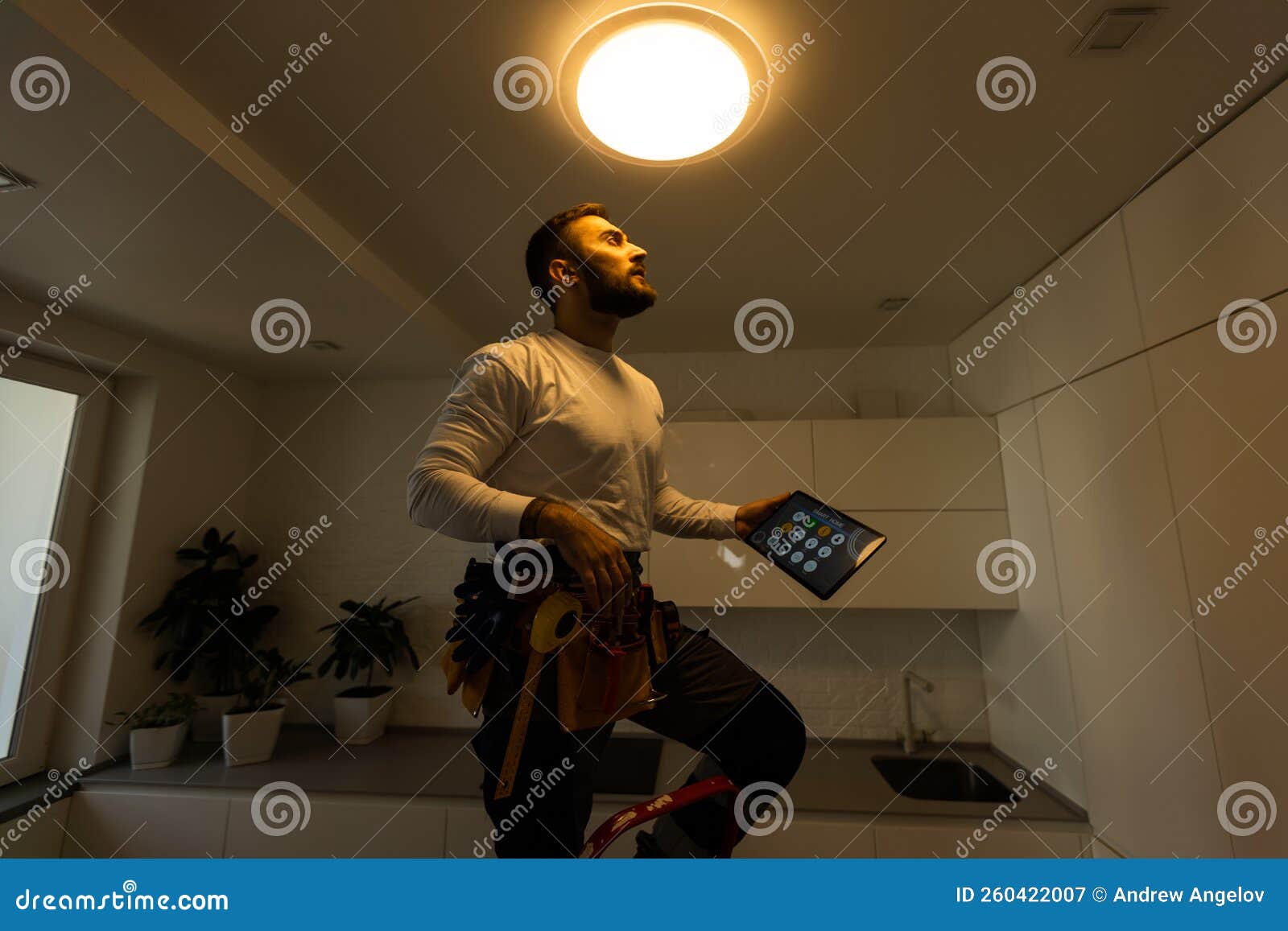 Installation Lighting. Builder is Holding a Tablet in His Hands ...