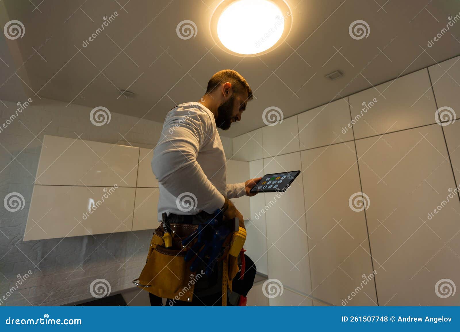 Installation Lighting. Builder is Holding a Tablet in His Hands ...