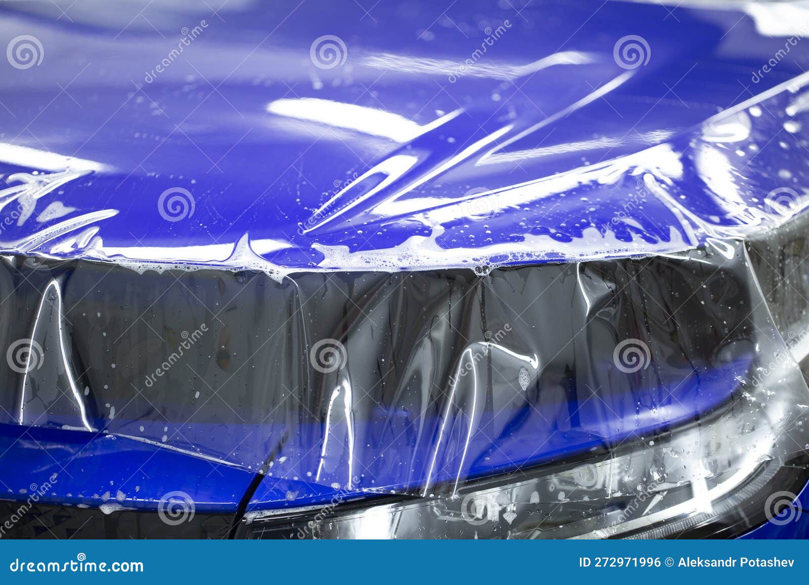 Installation of a Protective Film for Car Paint.the Workers Install a ...
