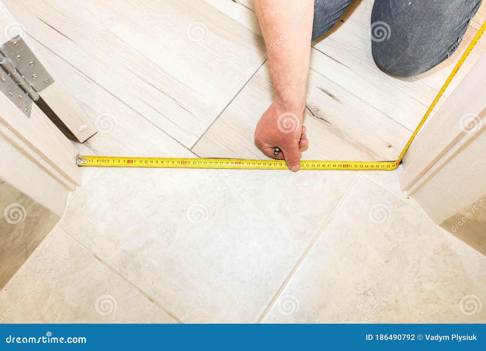 Installation of Threshold Indoors. Man with a Measuring Tape Stock ...