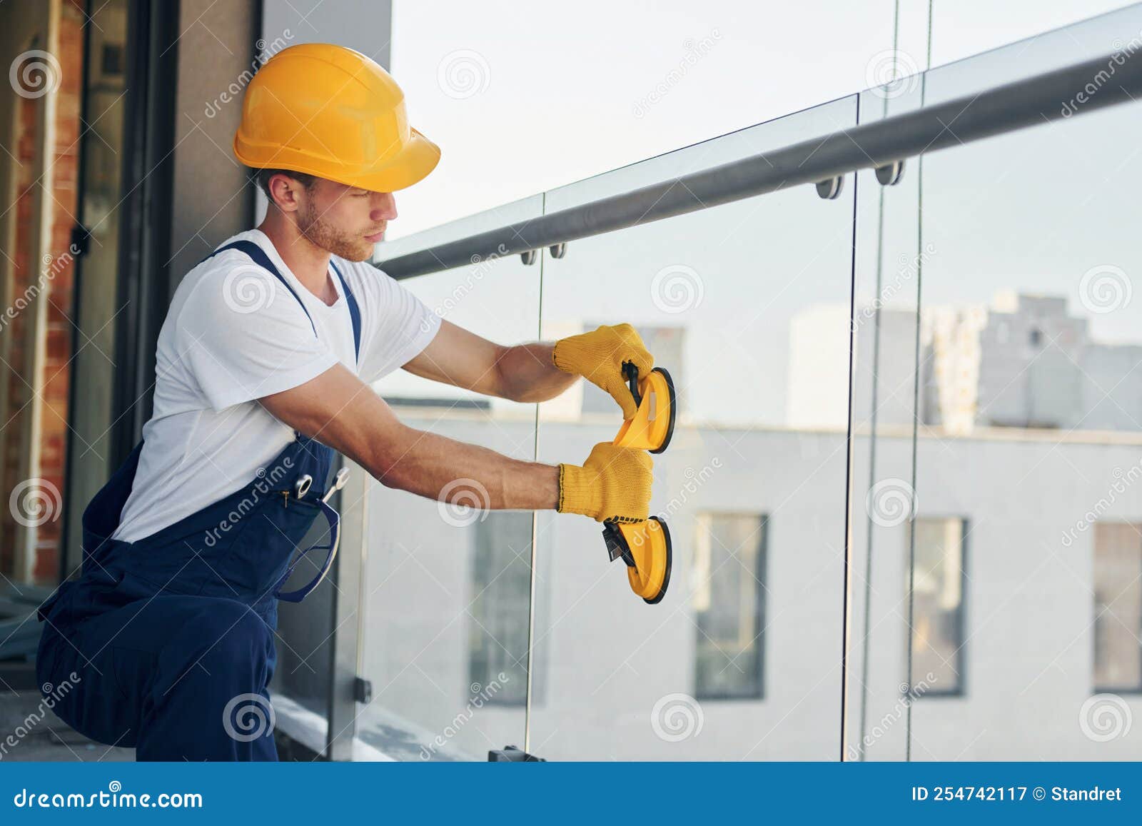 Installation of Windows. Young Man Working in Uniform at Construction ... Installation of Windows. Young Man Working in Uniform at Construction ...