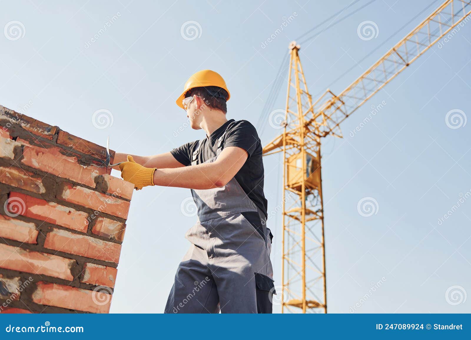 Installing Brick Wall. Construction Worker in Uniform and Safety ...