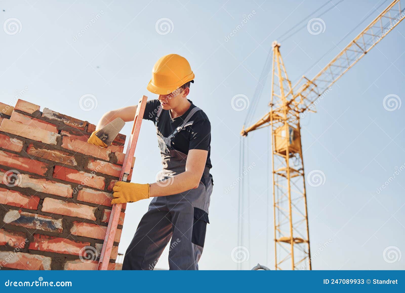 Installing Brick Wall. Construction Worker in Uniform and Safety ...