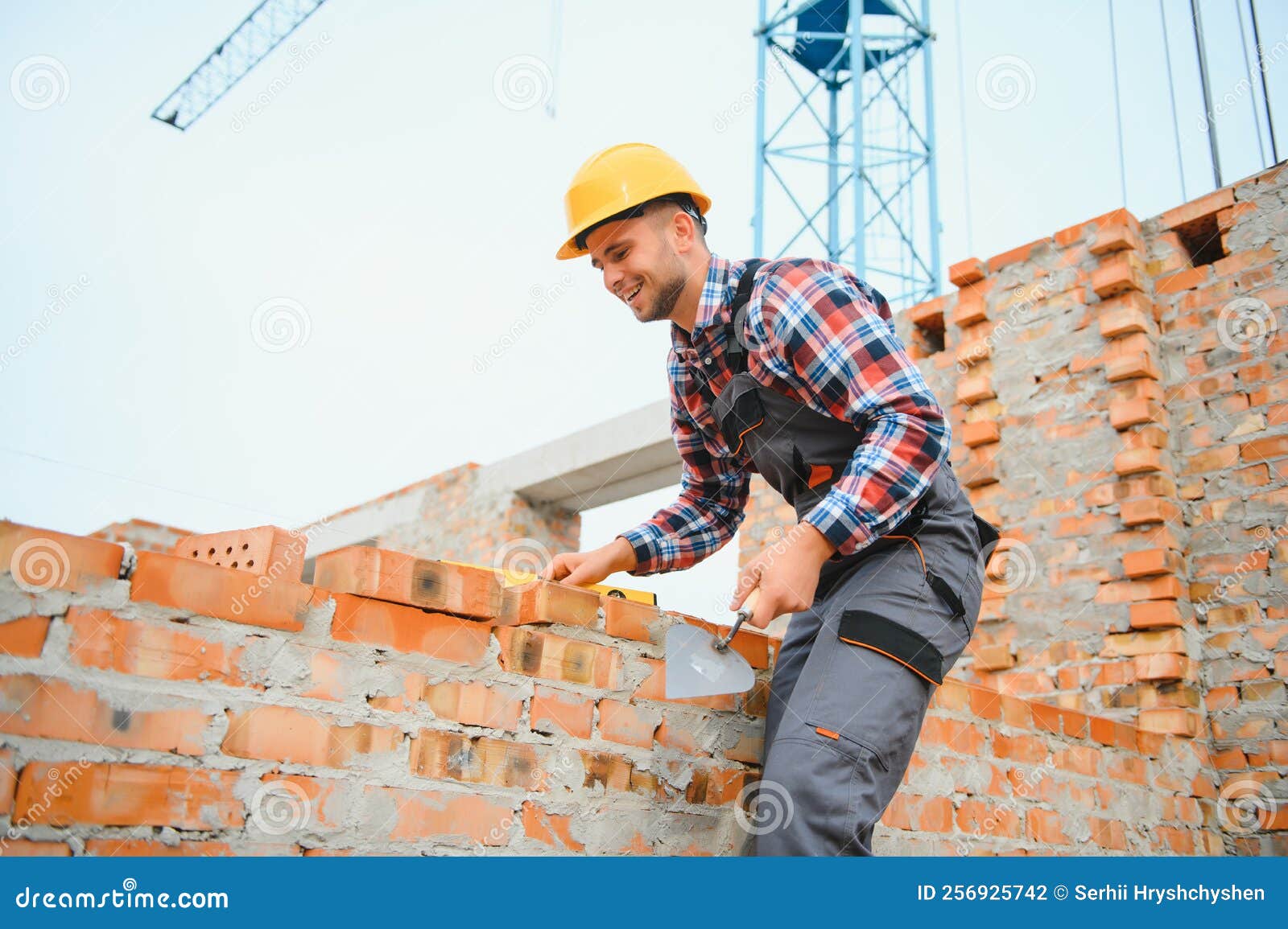 Installing Brick Wall. Construction Worker in Uniform and Safety ...