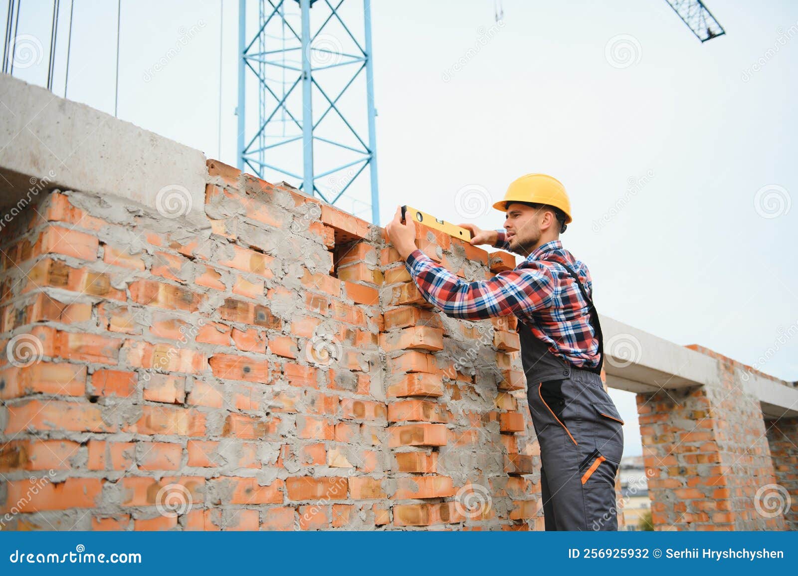 Installing Brick Wall. Construction Worker in Uniform and Safety ...