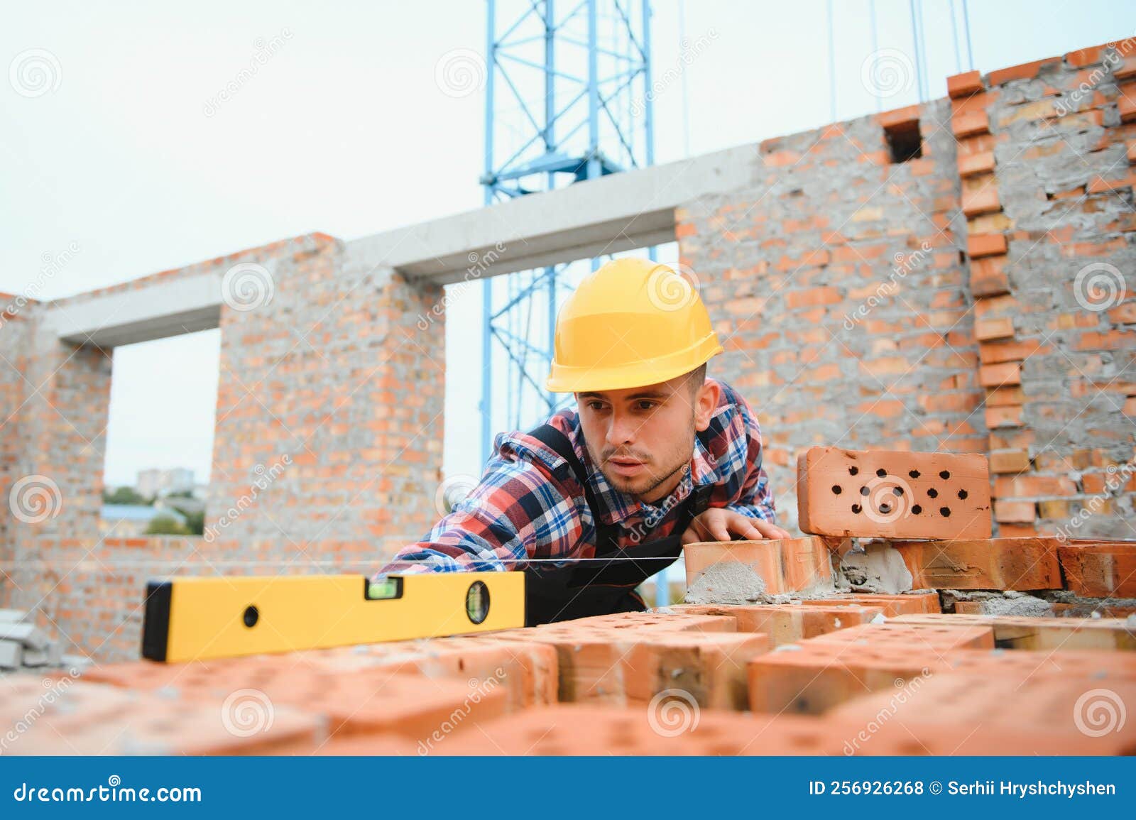 Installing Brick Wall. Construction Worker in Uniform and Safety ...