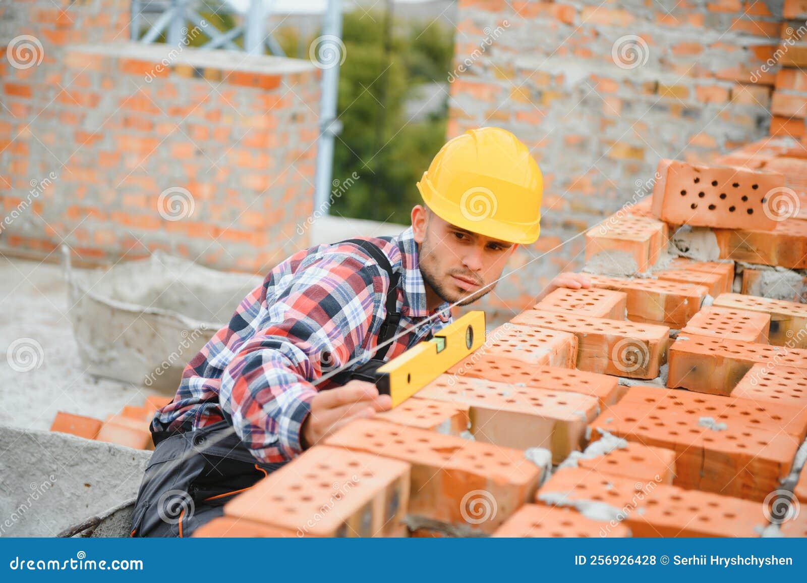 Installing Brick Wall. Construction Worker in Uniform and Safety ...