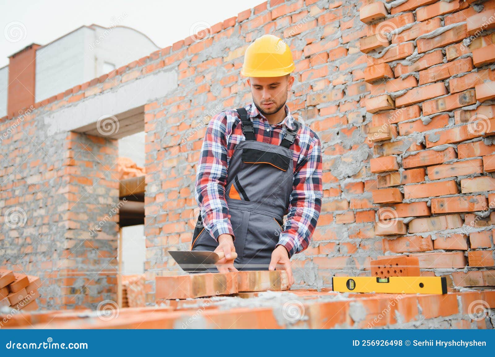 Installing Brick Wall. Construction Worker in Uniform and Safety ...