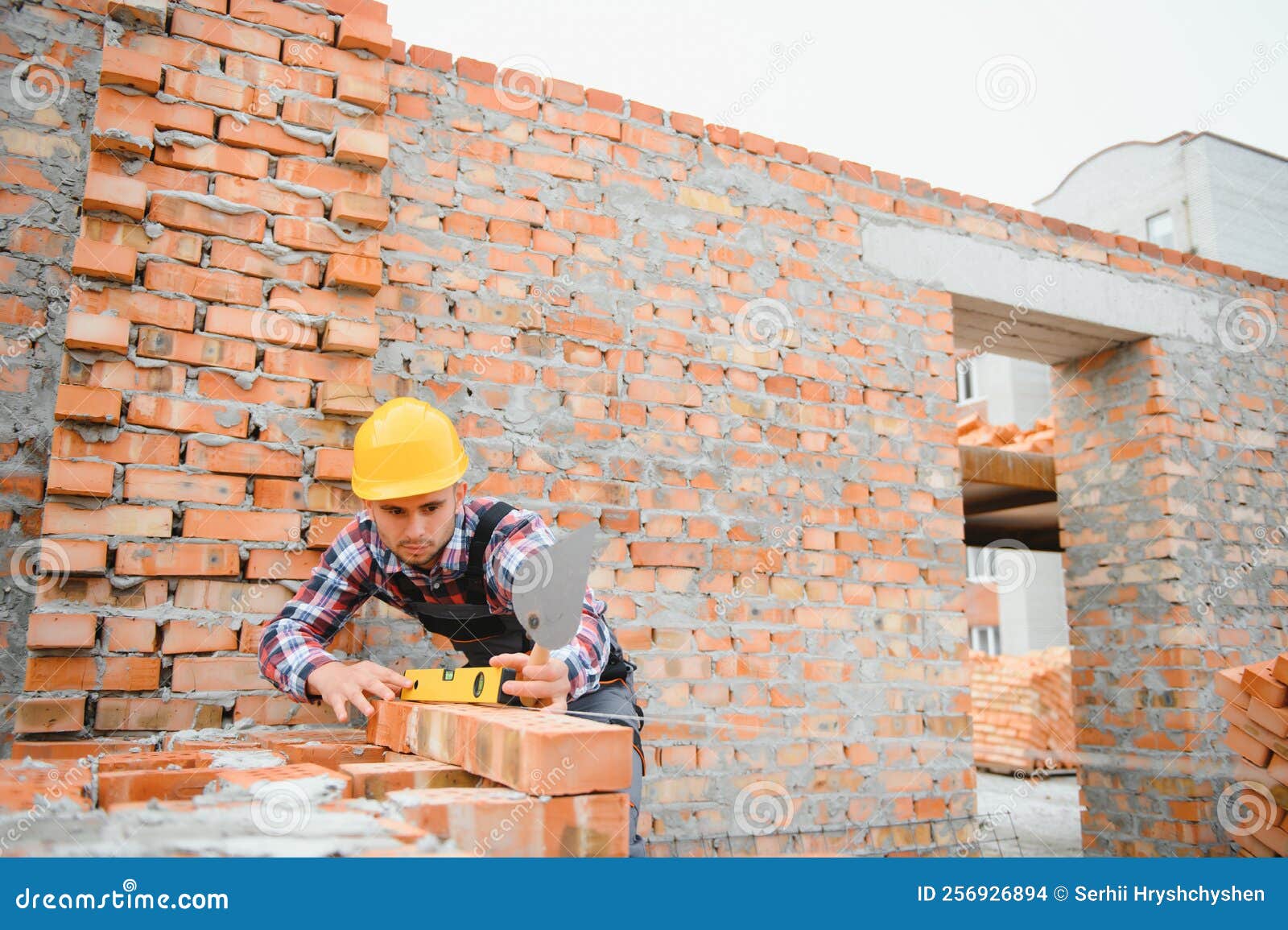 Installing Brick Wall. Construction Worker in Uniform and Safety ...