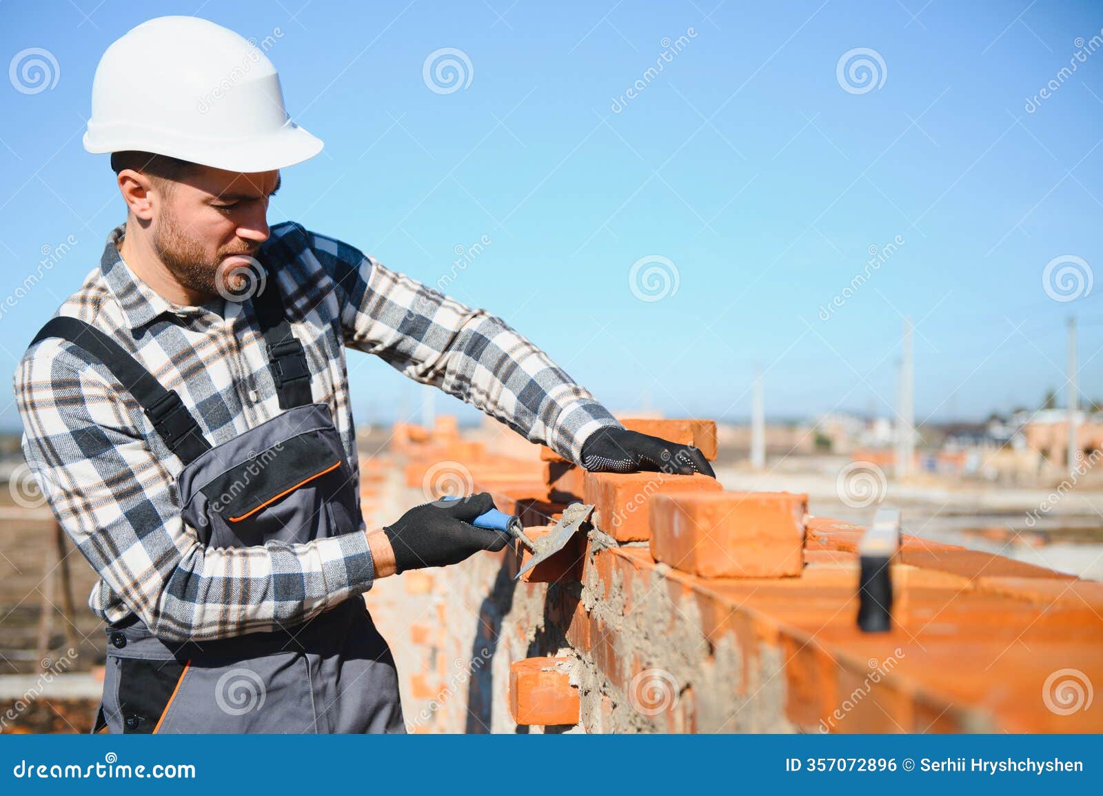 Installing Brick Wall. Construction Worker in Uniform and Safety ...