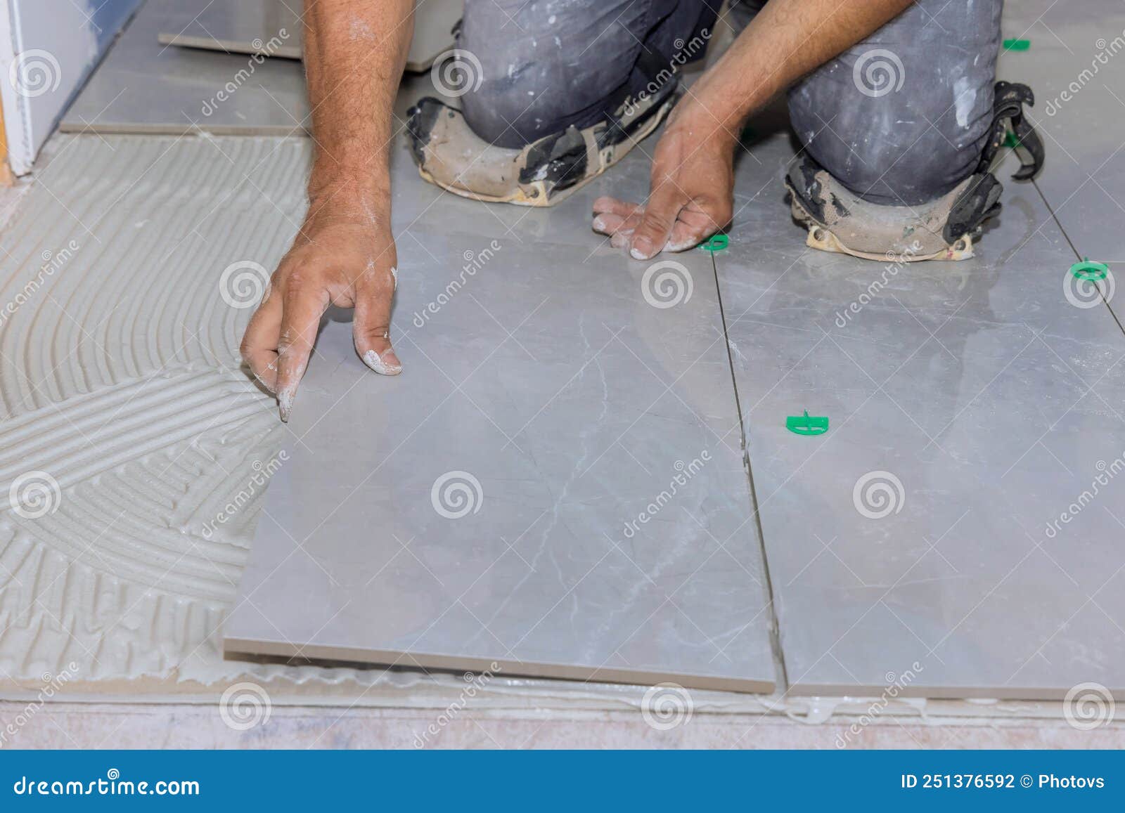 Installing Ceramic Tiles on an Adhesive Surface while Working on the ...